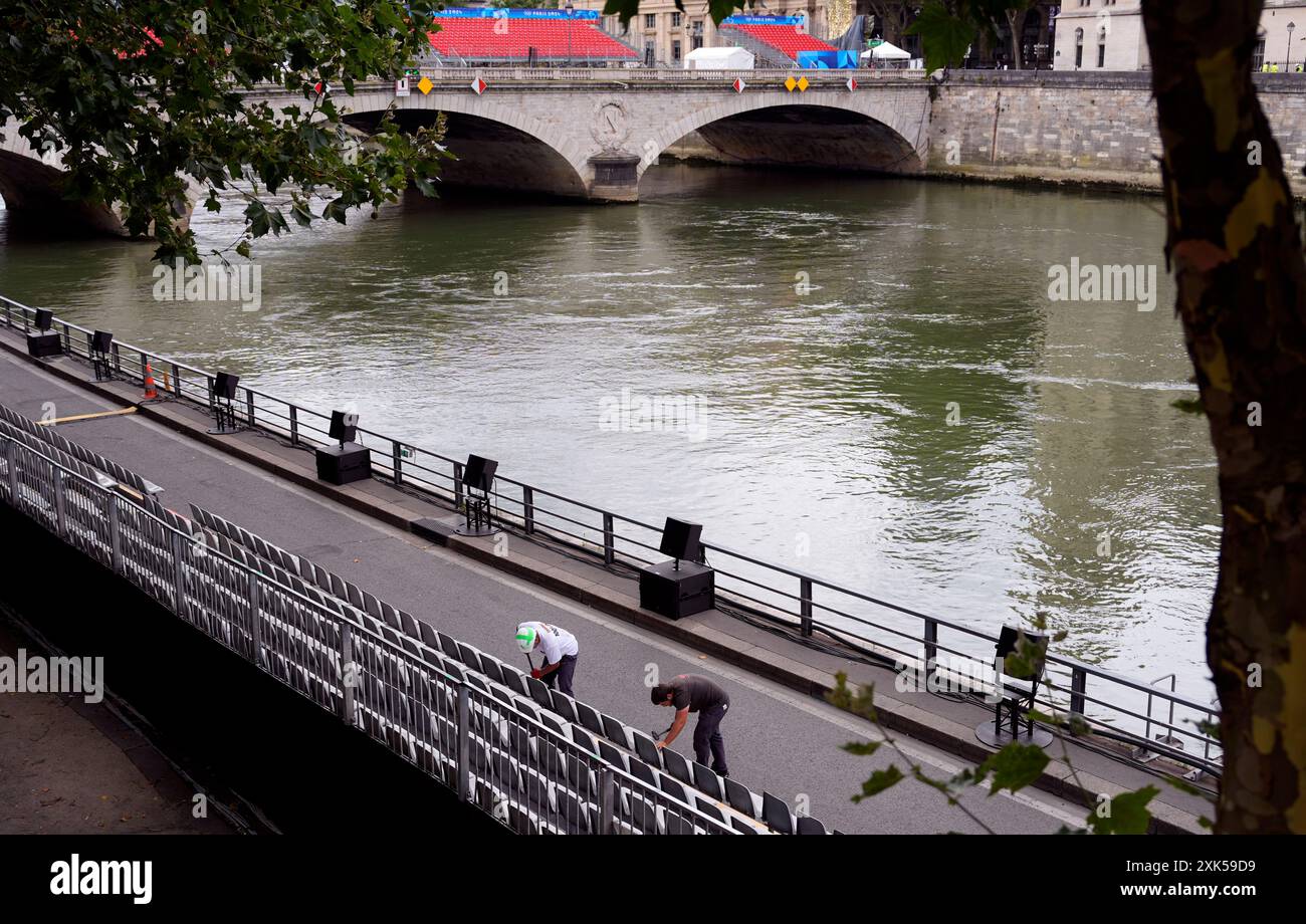Workers install seating along the Seine River ahead of the opening ...