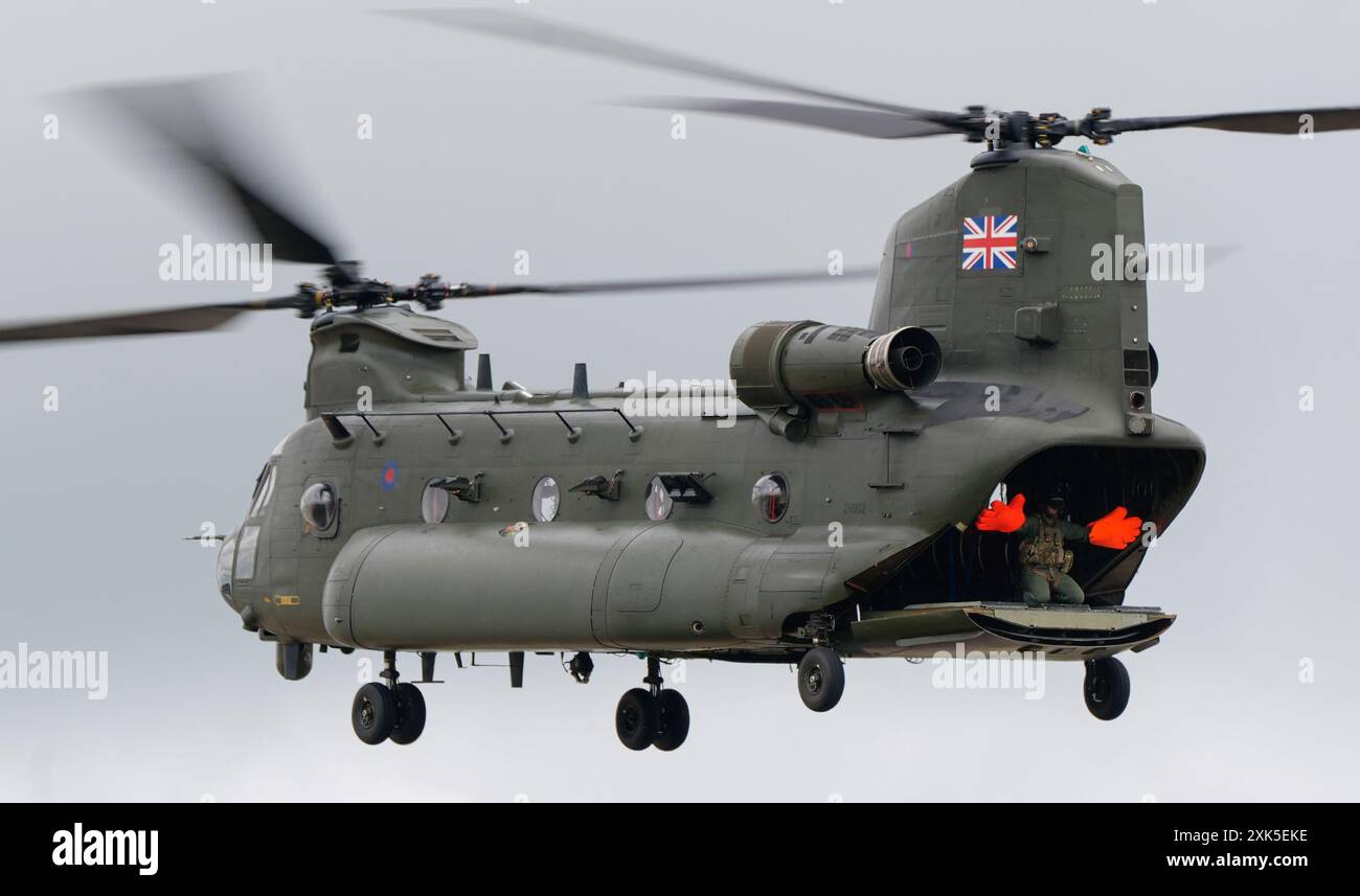 A crew member from the RAF Chinook Display Team waves large orange ...