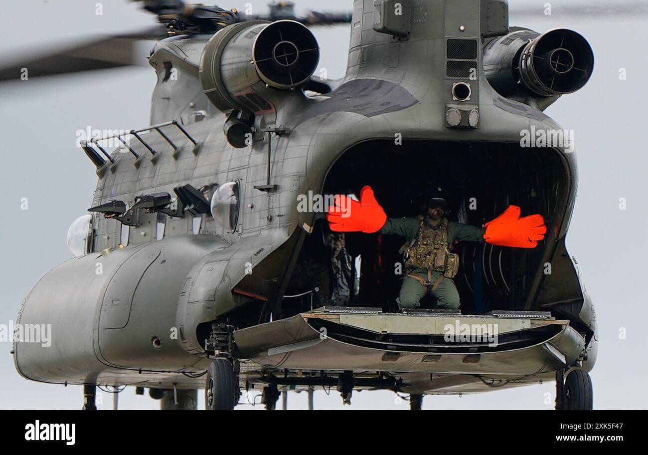 A crew member from the RAF Chinook Display Team waves large orange ...