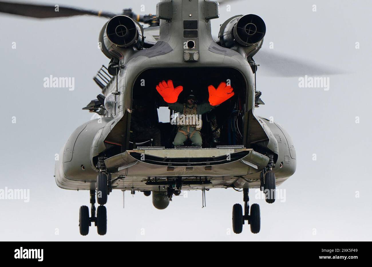 A crew member from the RAF Chinook Display Team waves large orange ...