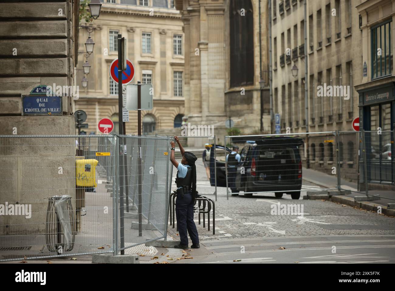 A police officer attaches fences at the security perimeter at the 2024 ...