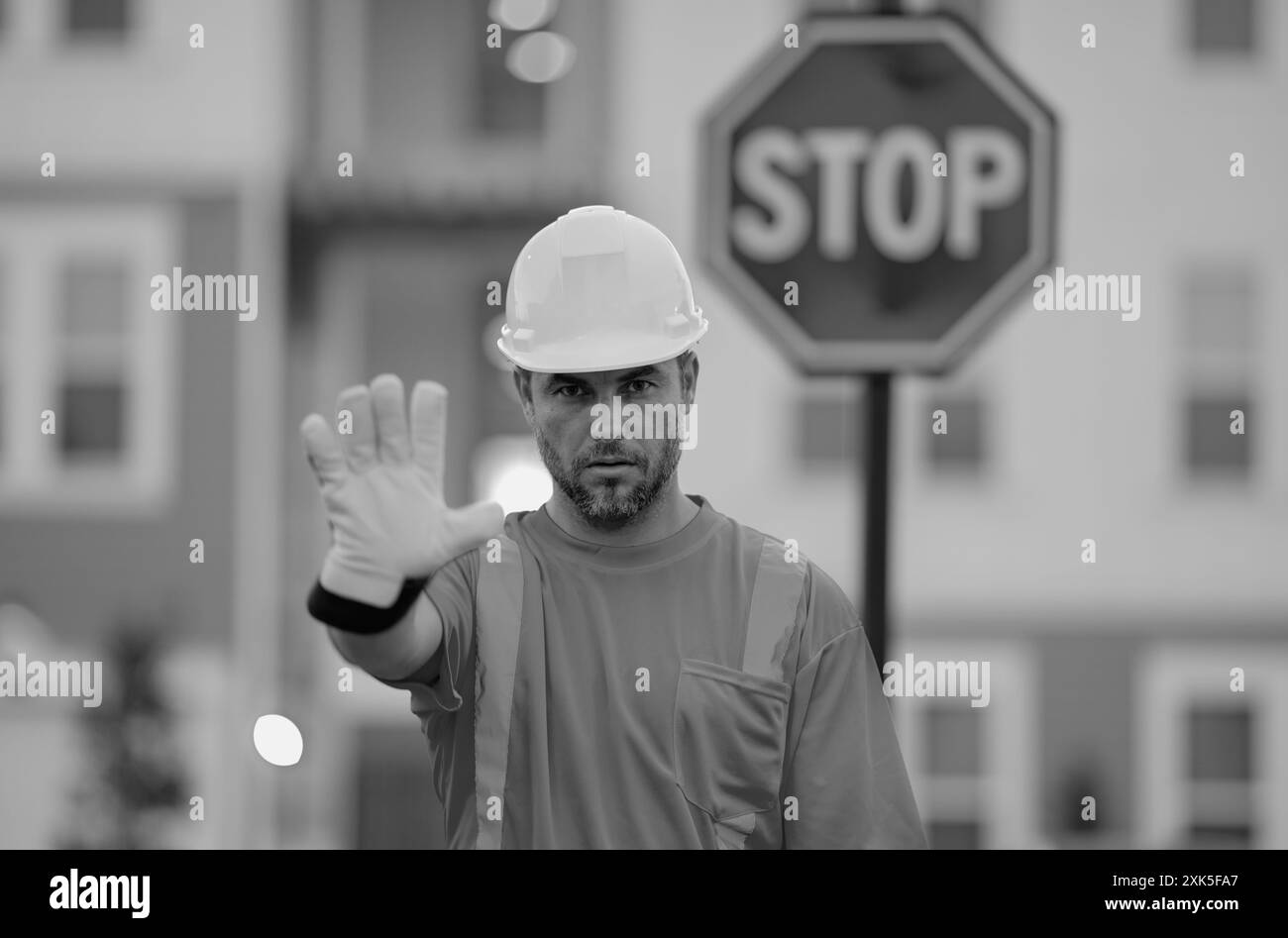 Worker builder in hard hat with stop road sign. Builder with stop ...