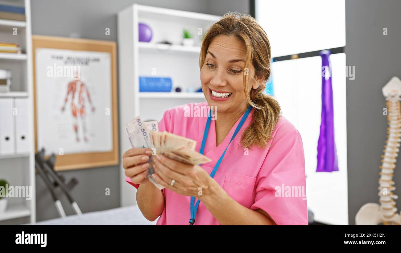 A happy woman in a pink medical uniform counting colombian pesos in a ...