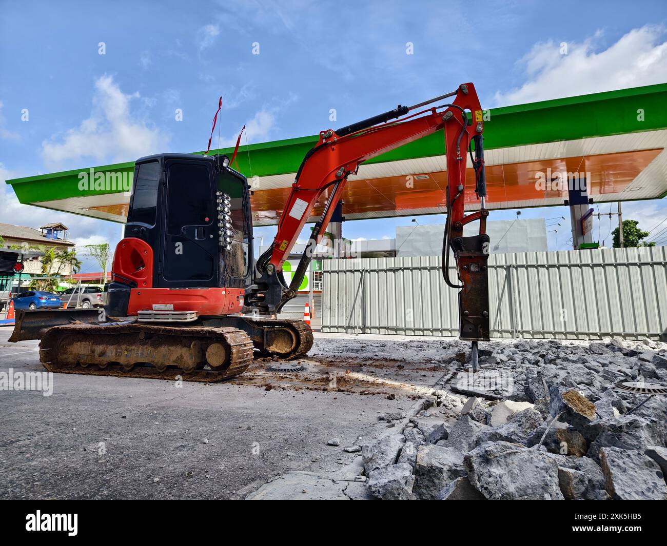 Excavator using hydraulic hammer for breaking concrete at a ...
