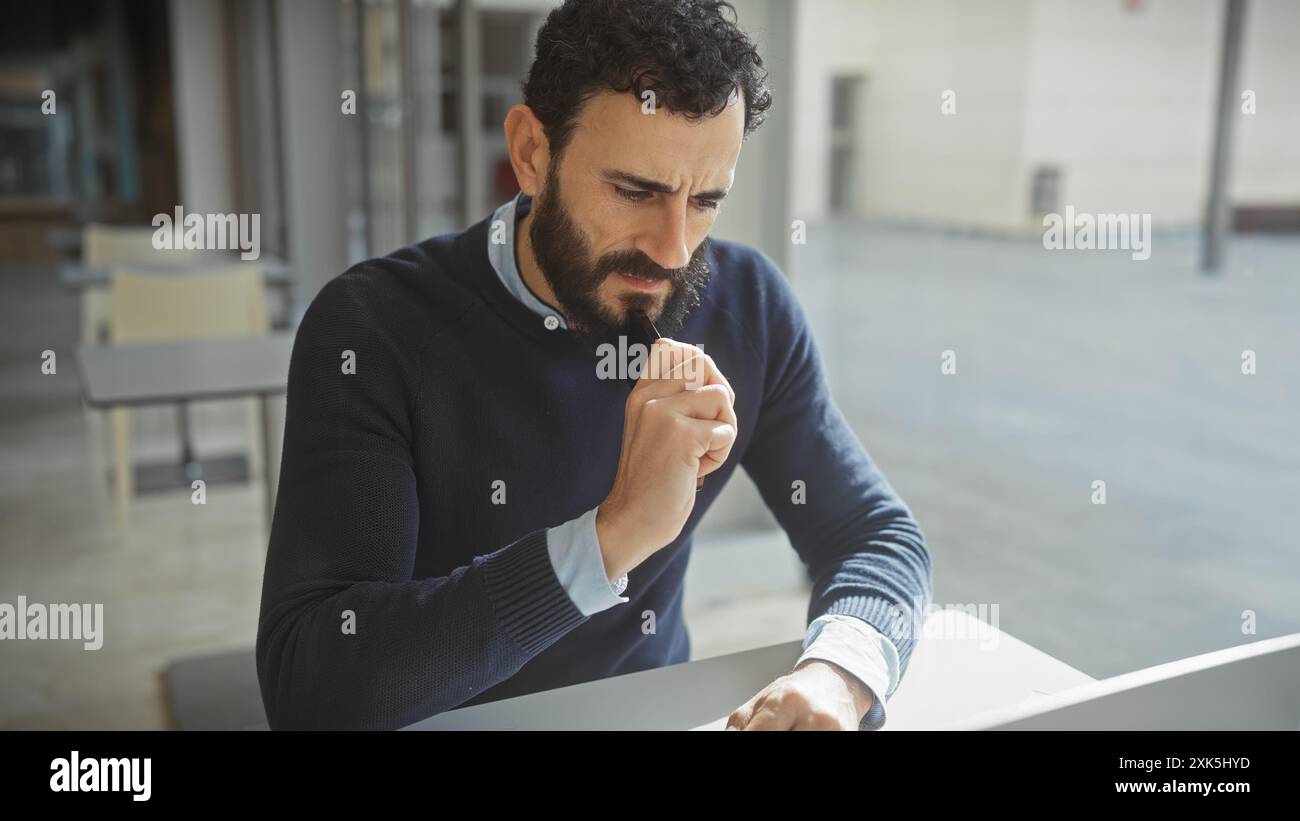 Bearded man pondering in modern office, showing thoughtfulness ...