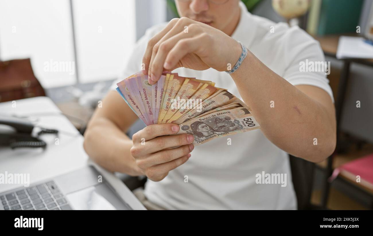Hispanic man counting mexican pesos in a modern office, exemplifying ...