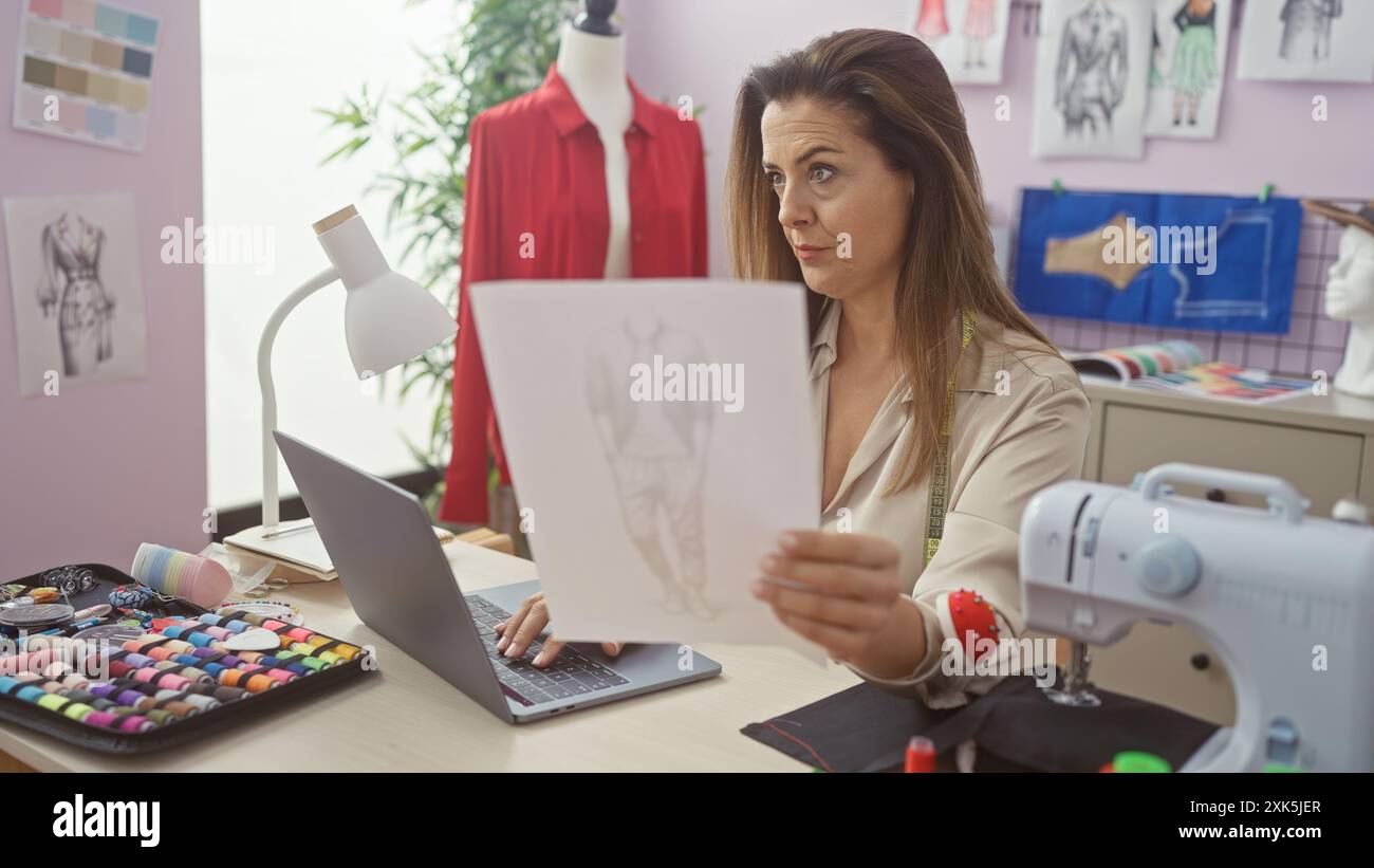 Focused hispanic woman examining a fashion sketch in a modern atelier ...