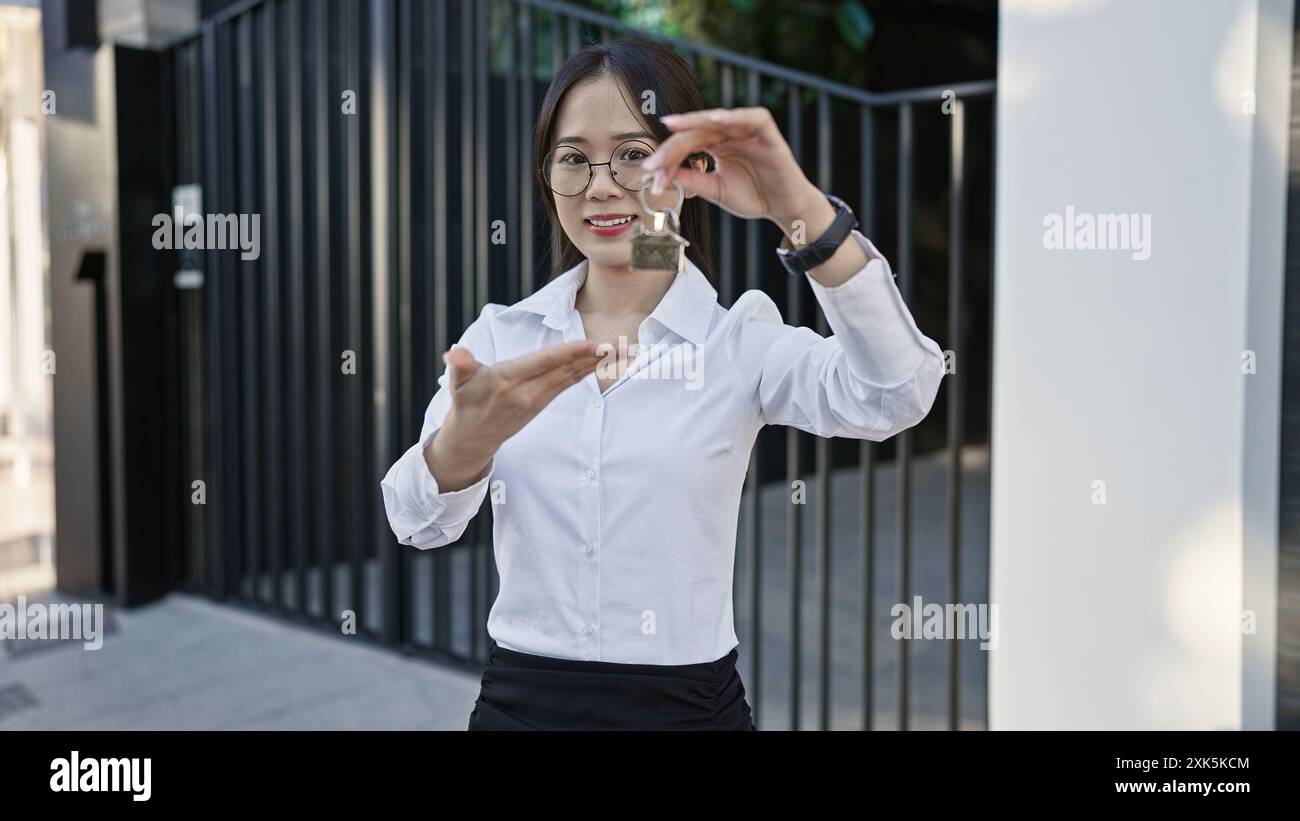 Young asian woman holding keys on urban street Stock Photo - Alamy