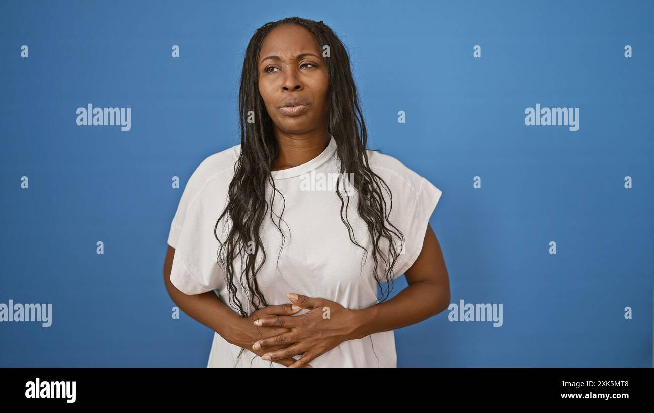 A young adult african american woman with curly hair stands against a ...