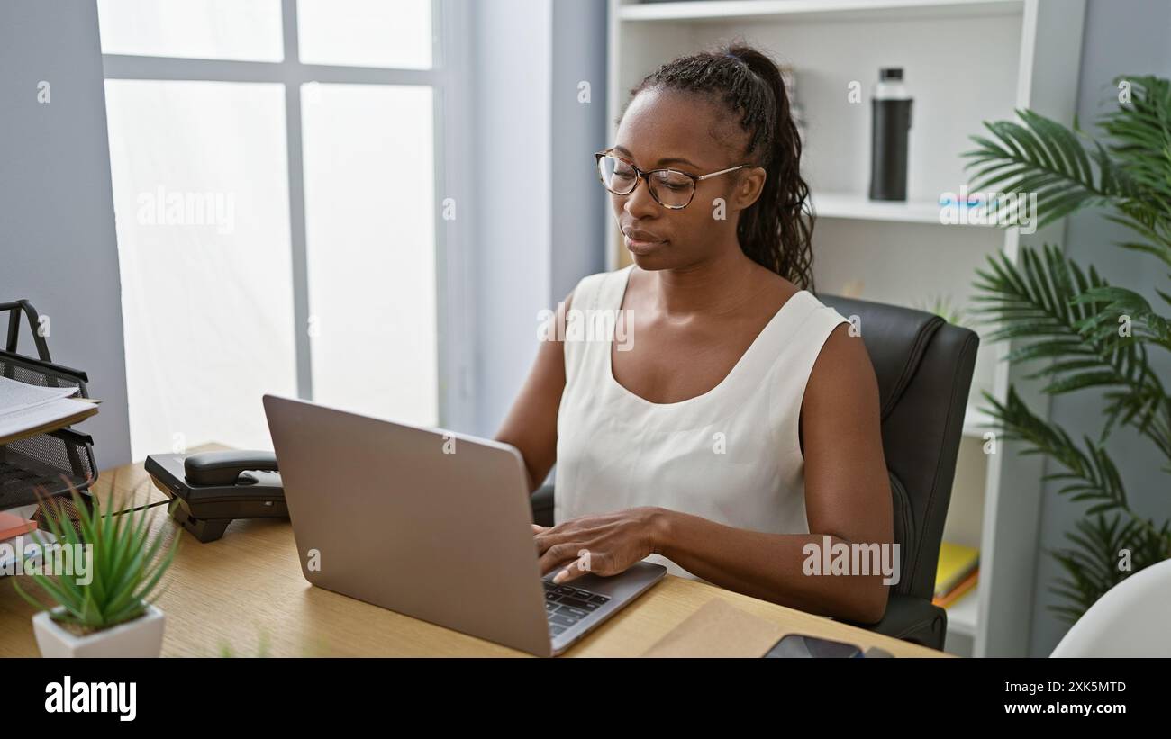 A professional african american woman working attentively on her laptop ...