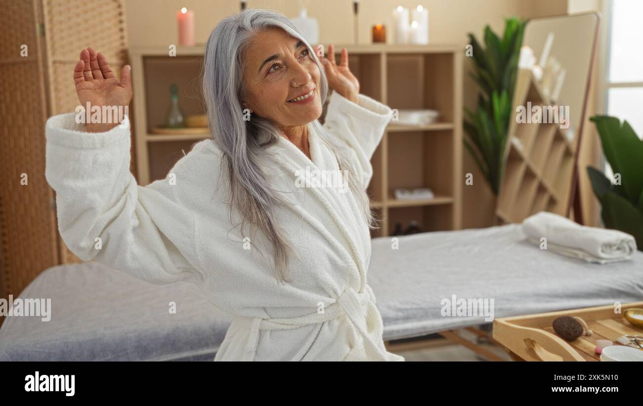 Woman relaxing in a spa wearing a white robe with grey hair in a ...