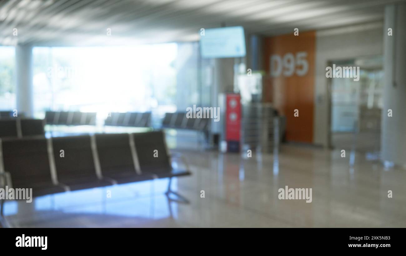 Blurred airport terminal with empty seating and defocused signage in ...