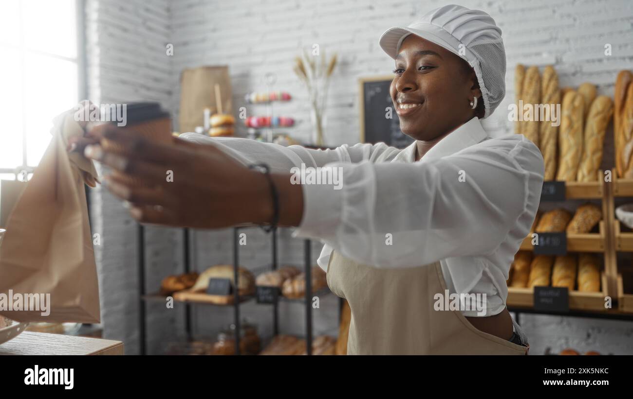 African american woman working in a bakery handing over a takeaway ...