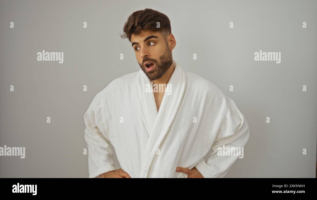 Handsome young hispanic man with a beard wearing a white robe over an ...