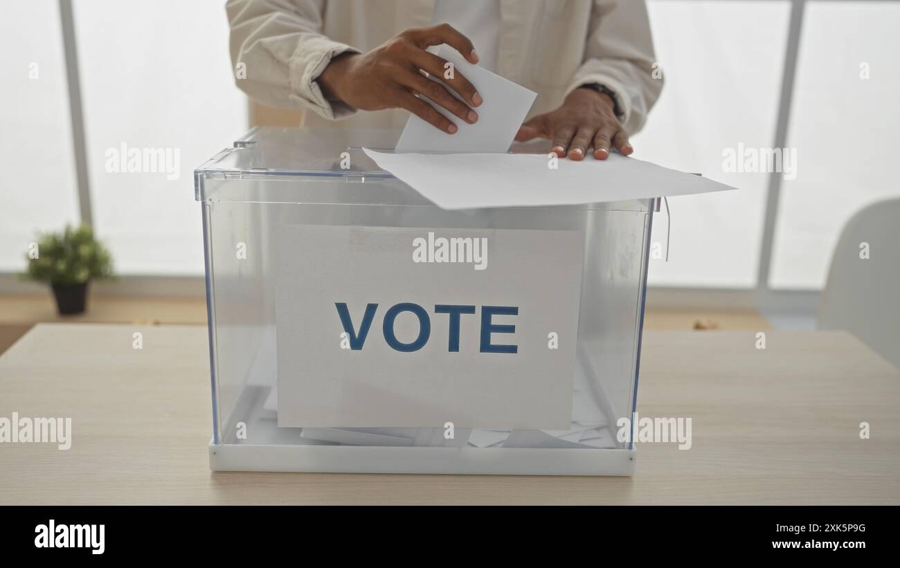 An african american man casts his vote in an indoor electoral college ...