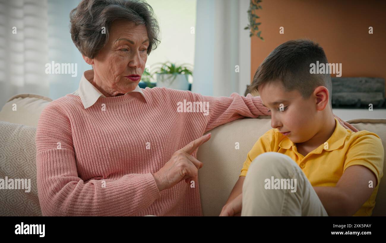 Strict elderly woman grandmother pensioner scold naughty offended kid ...