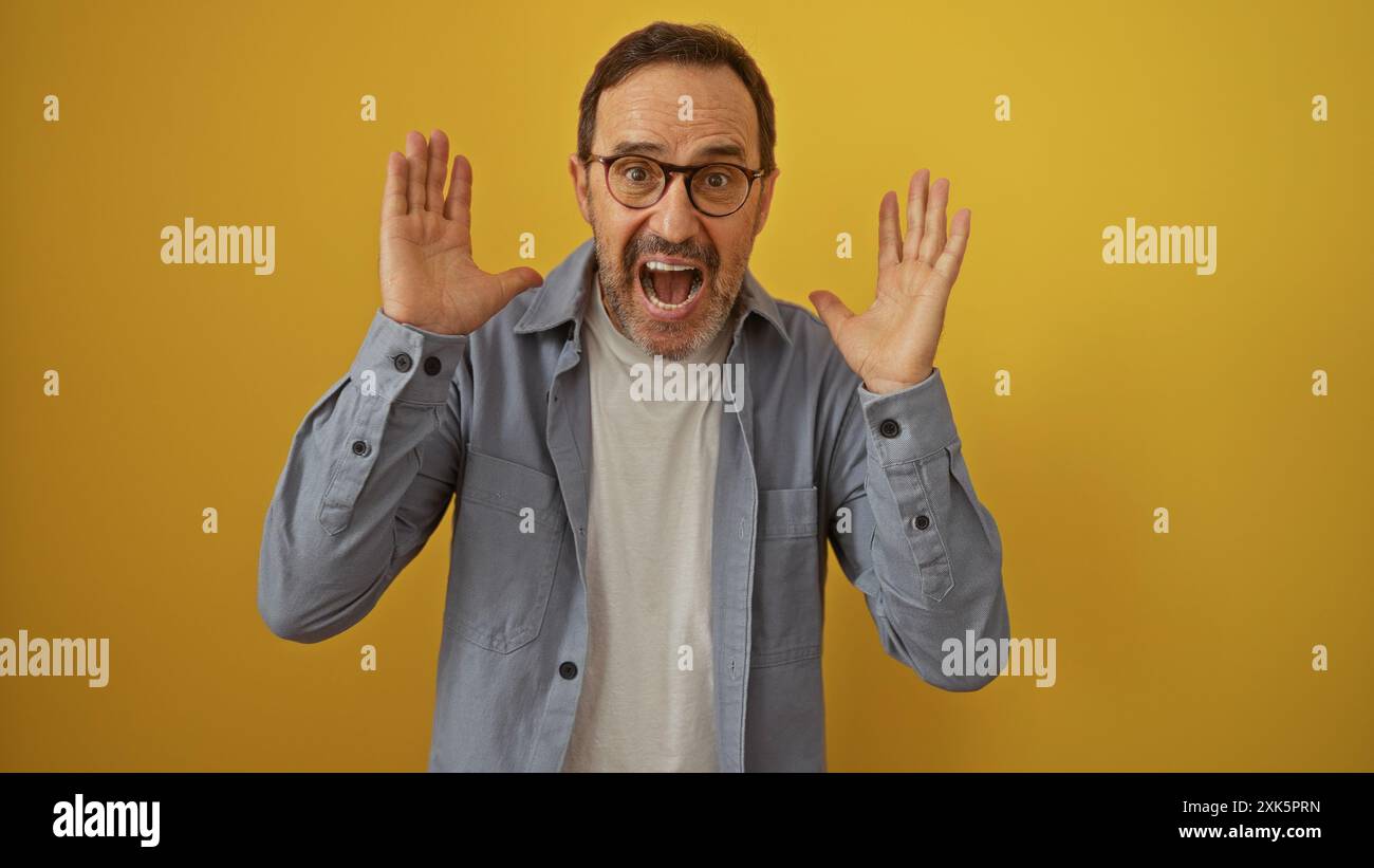 Hispanic man expressing excitement with hands raised, standing over an ...