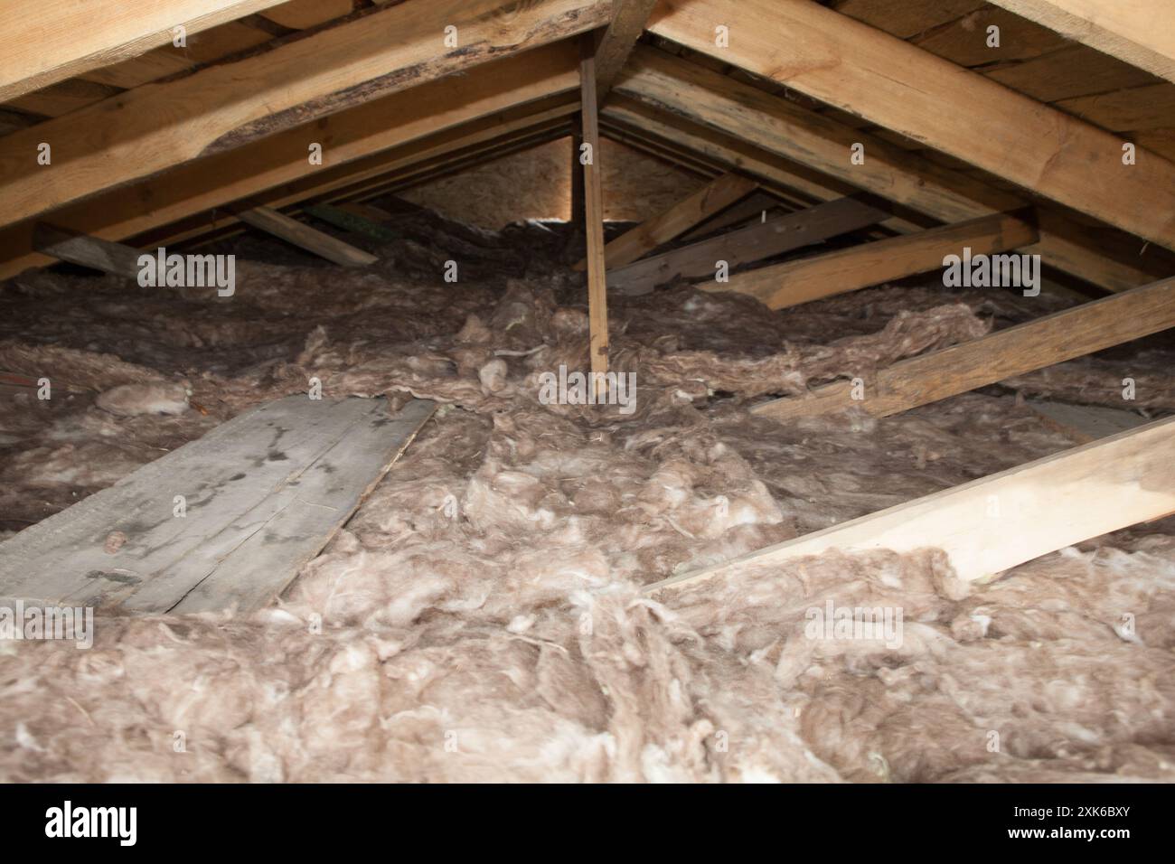 Construction worker mineral wool thermally insulating house attic with ...