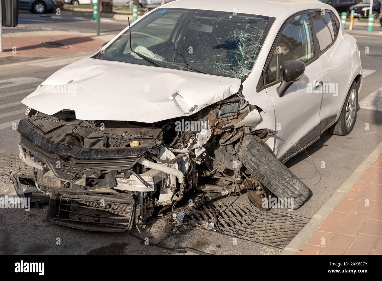 Severely damaged white car after an accident, showcasing the shattered ...