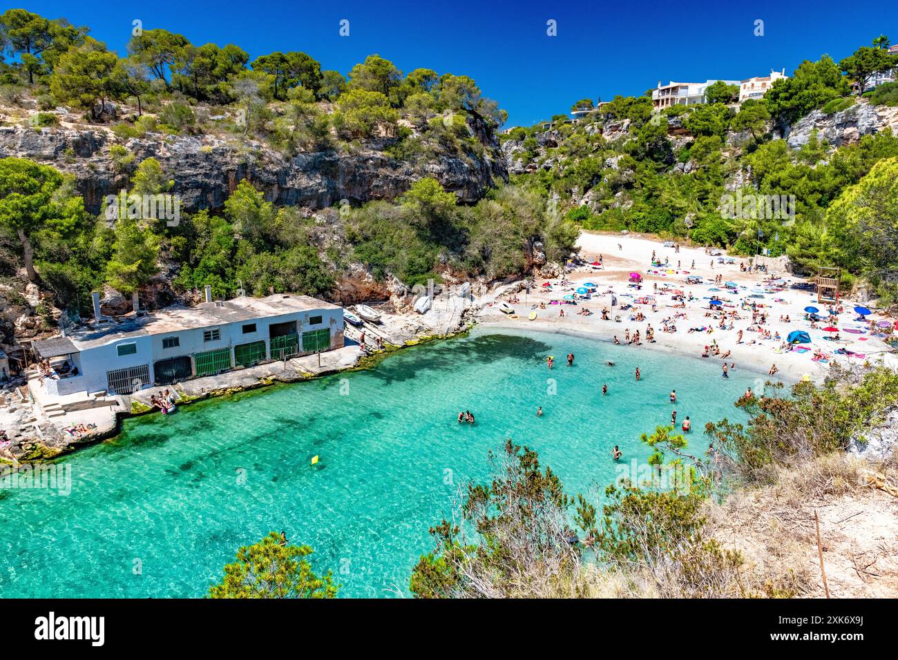 Bathing bay with crystal-clear water, sandy beach and boathouses in the ...