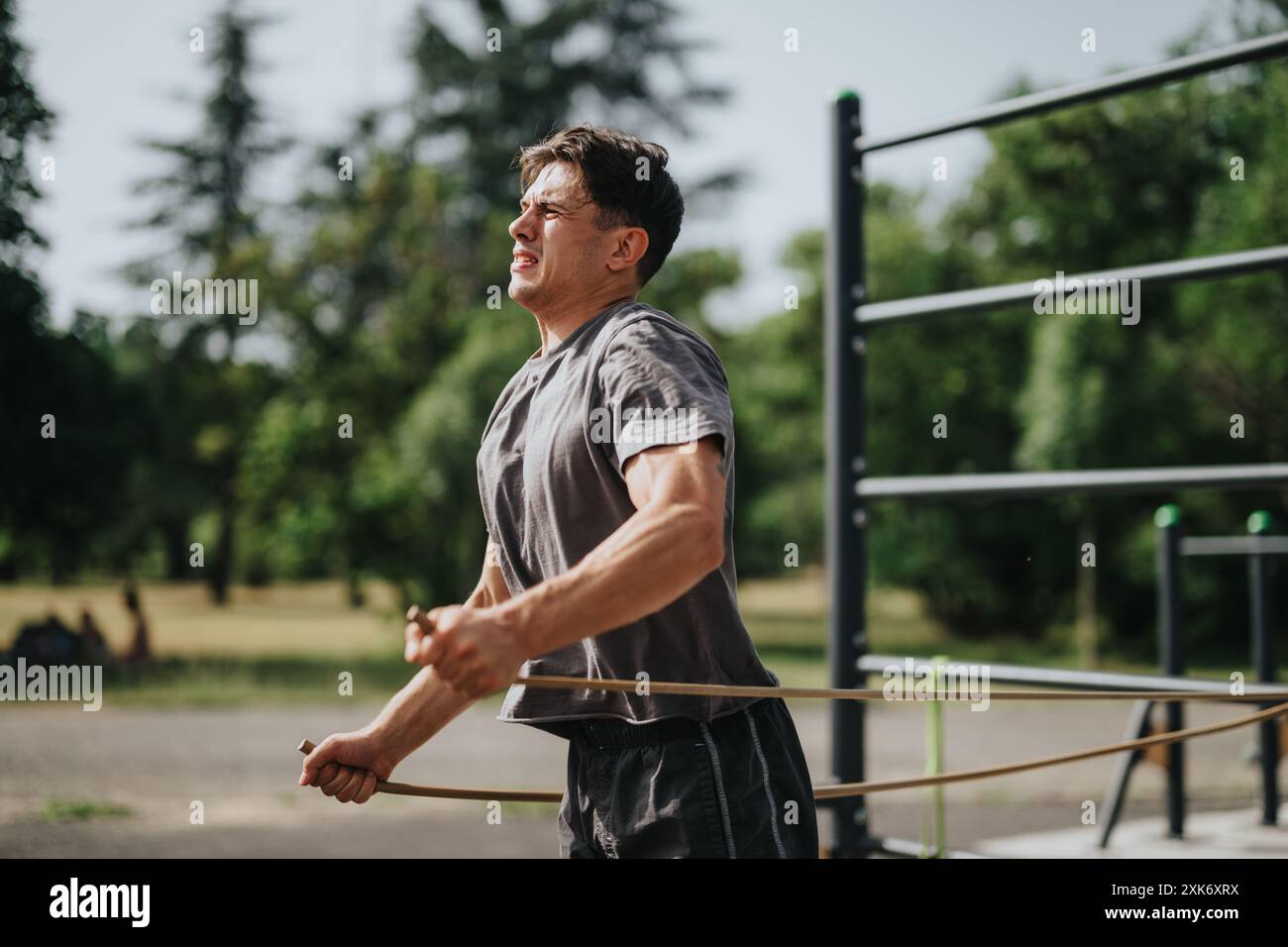 Man doing calisthenics workout with jump rope in outdoor park ...