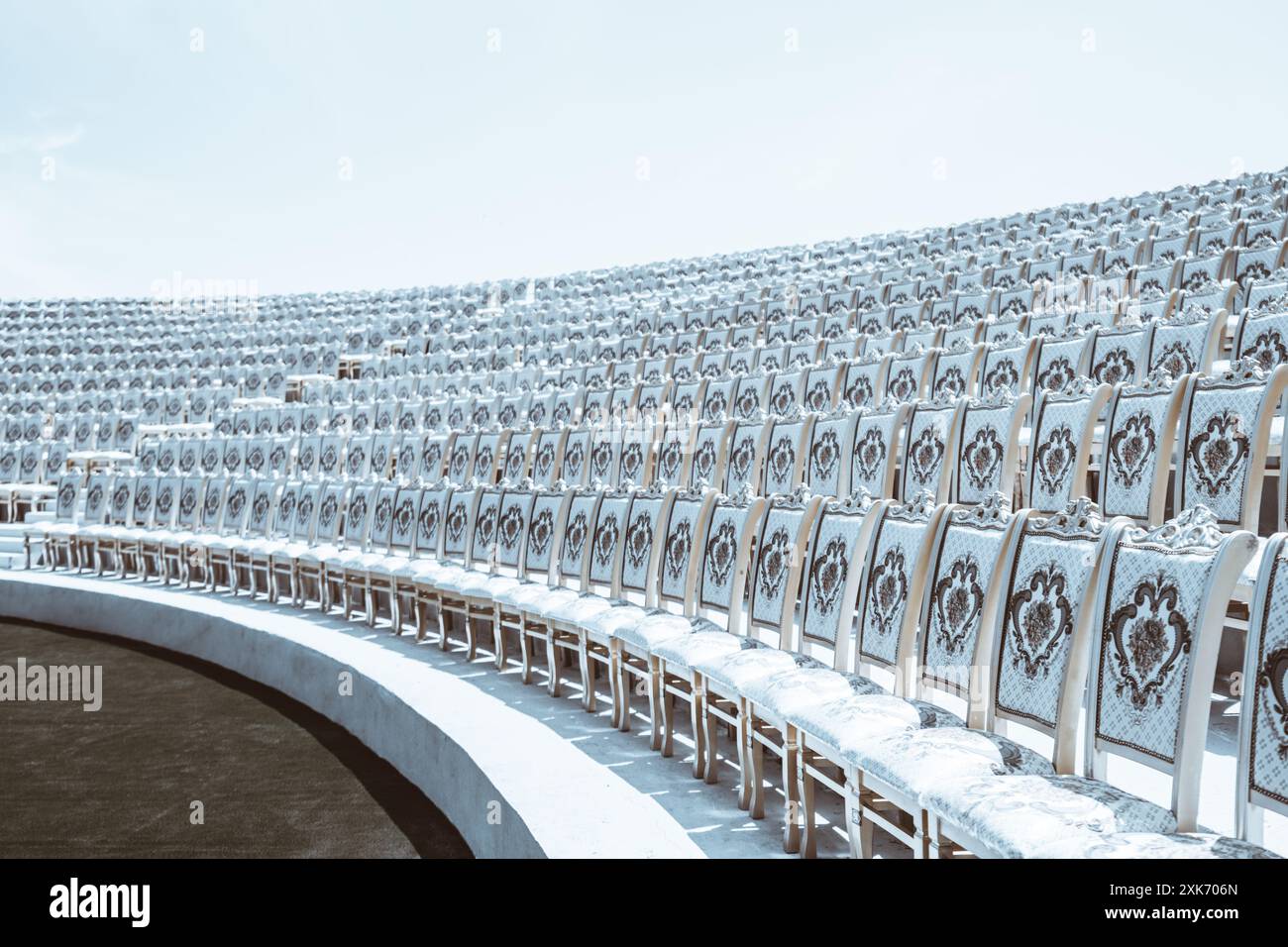 A large amphitheater filled with ornate, white chairs arranged in ...