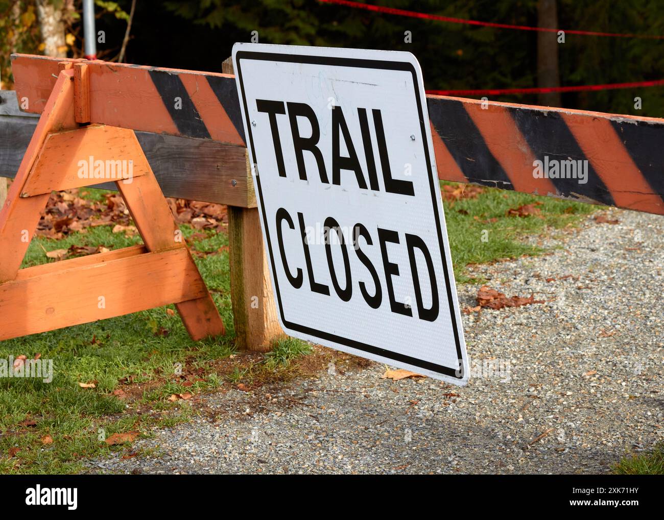 A white sign with the words, 'Trail Closed' on an orange and black ...