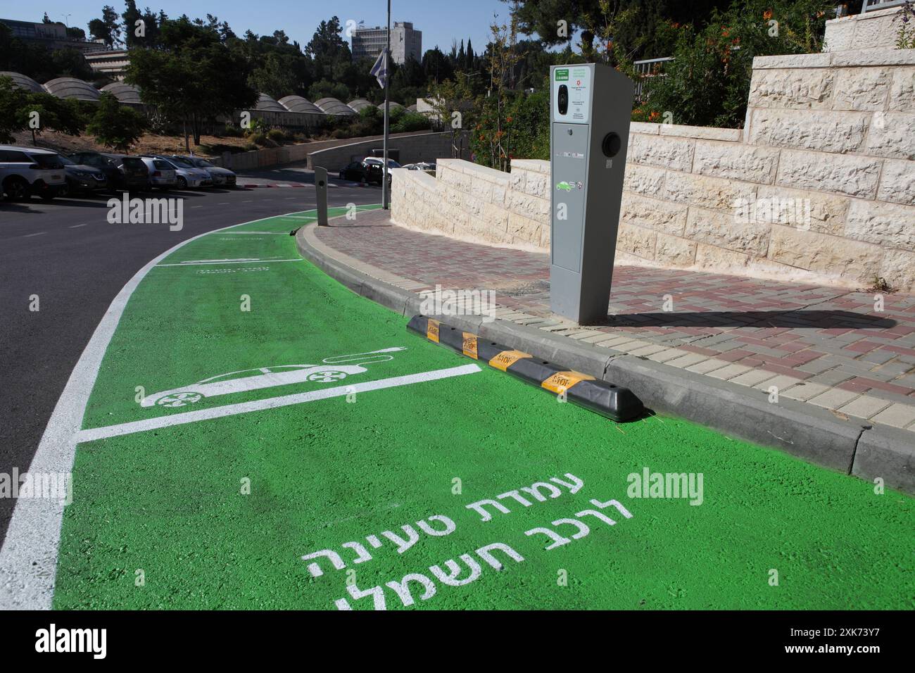 Residential neighborhood street electric car charging stations, green painted parking spaces by ...