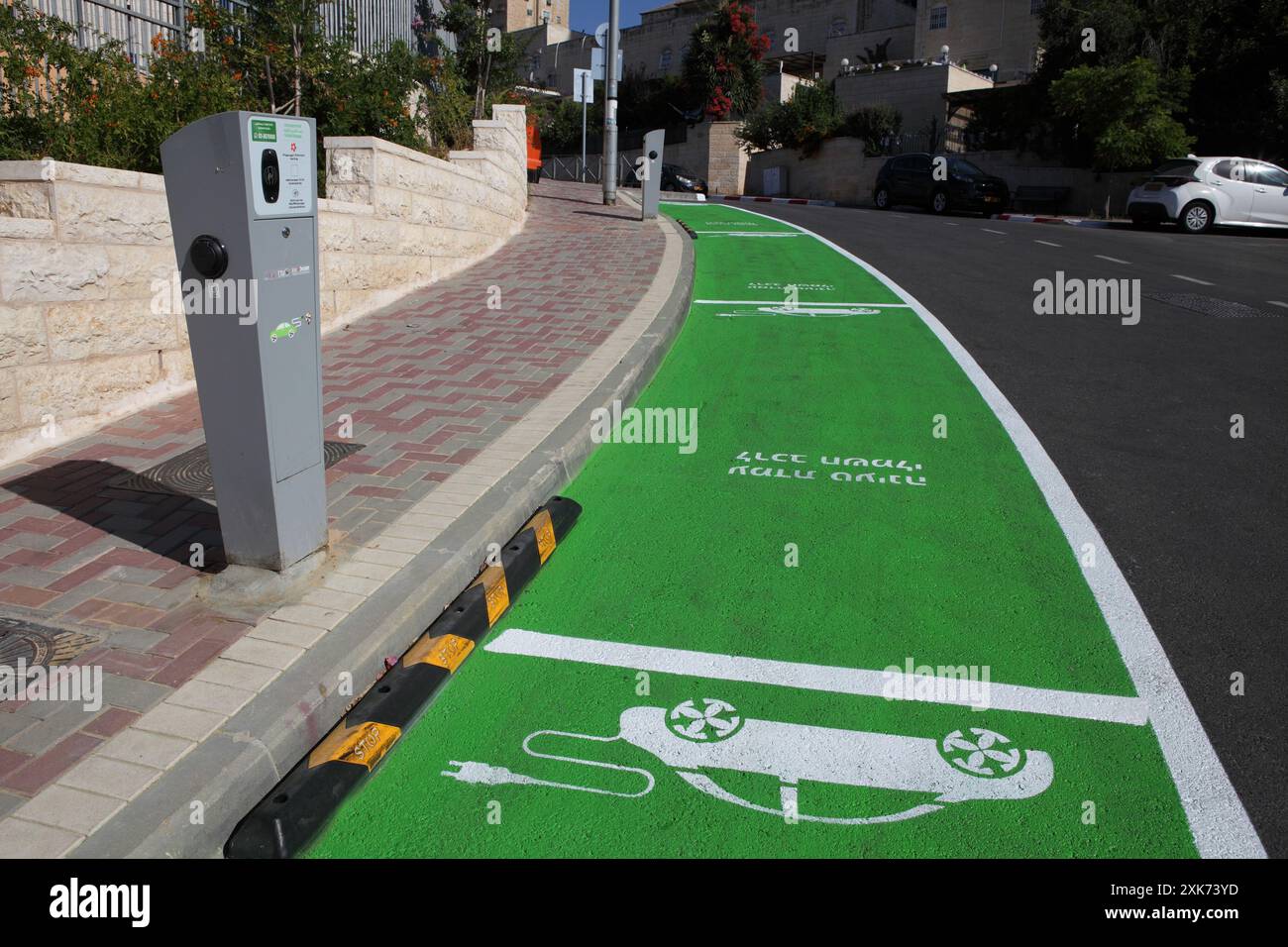 Residential neighborhood street electric car charging stations, green painted parking spaces by ...