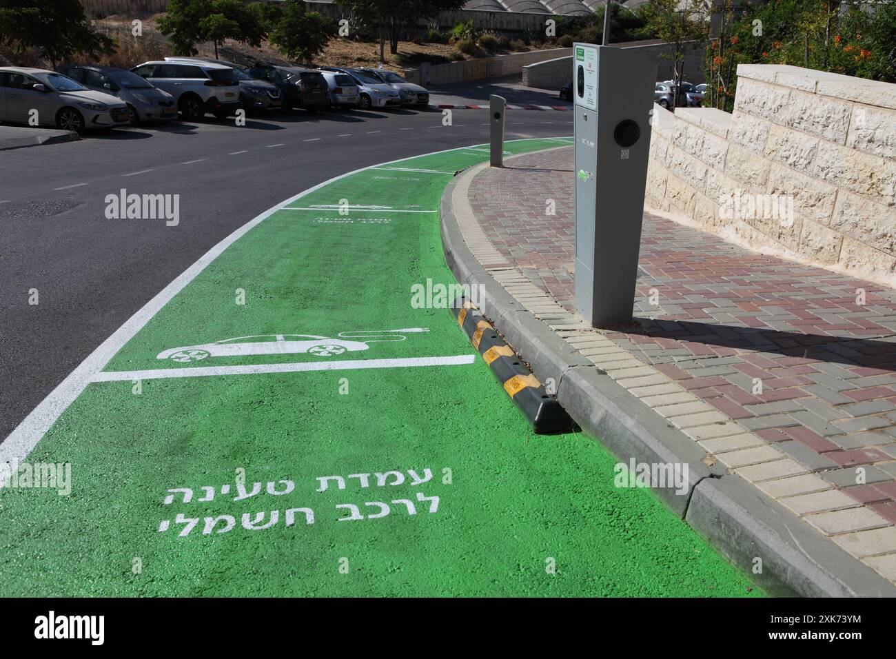 Residential neighborhood street electric car charging stations, green painted parking spaces by ...