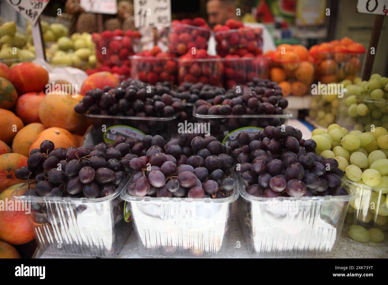 Fresh produce, mango, grapes, apricots, & cherry tomatoes for sale on a ...