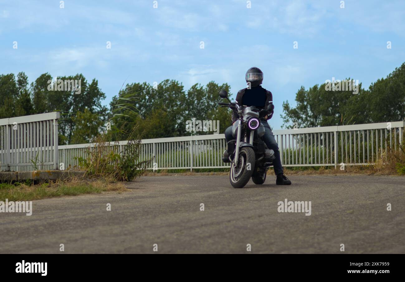 motorbike parked on the street in front of a bridge exiting a corner ...