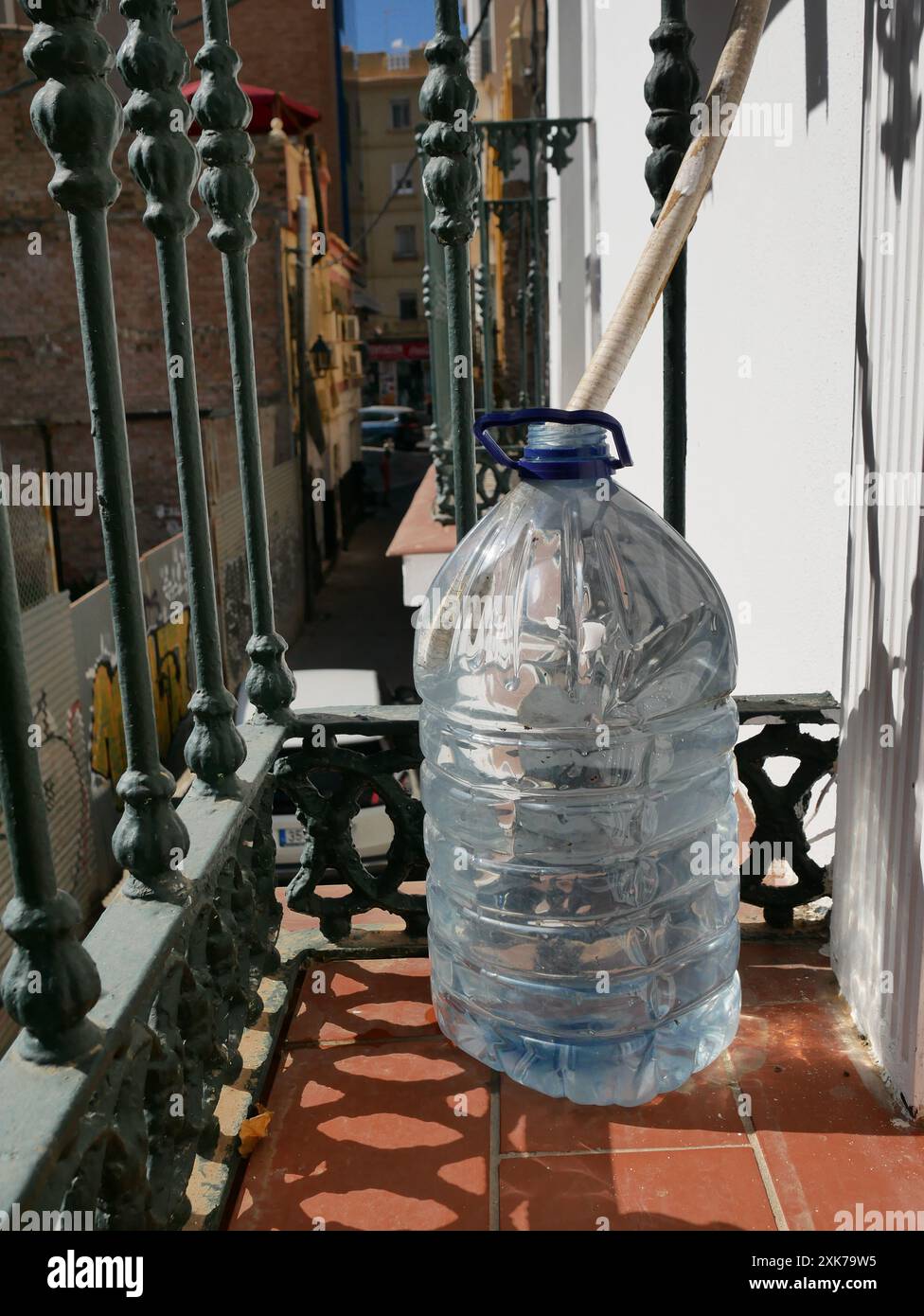 Bottle on balcony collecting condensate water from air conditioner for ...