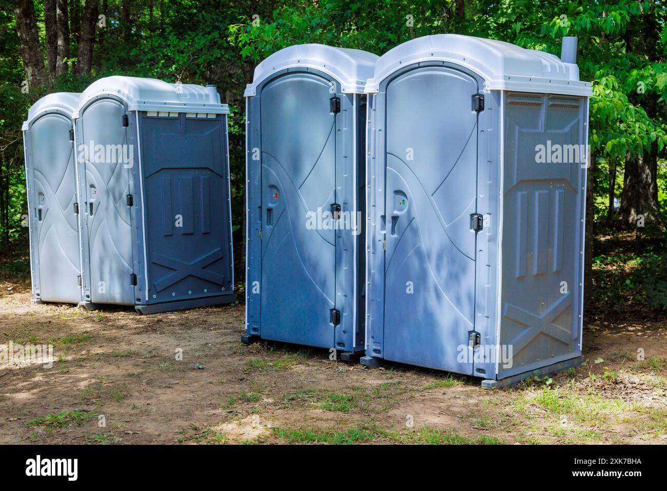 Several rows of portable chemical toilet cabins in city park center ...