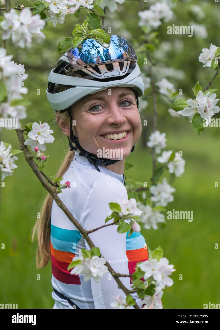 Portrait of a young female cyclist in cycling uniform, protective ...