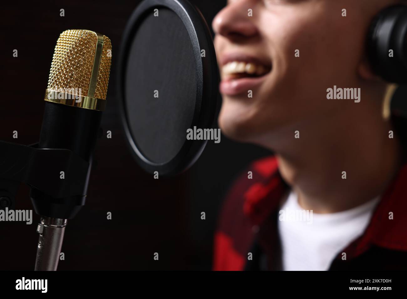 Vocalist singing into microphone in professional record studio, closeup ...