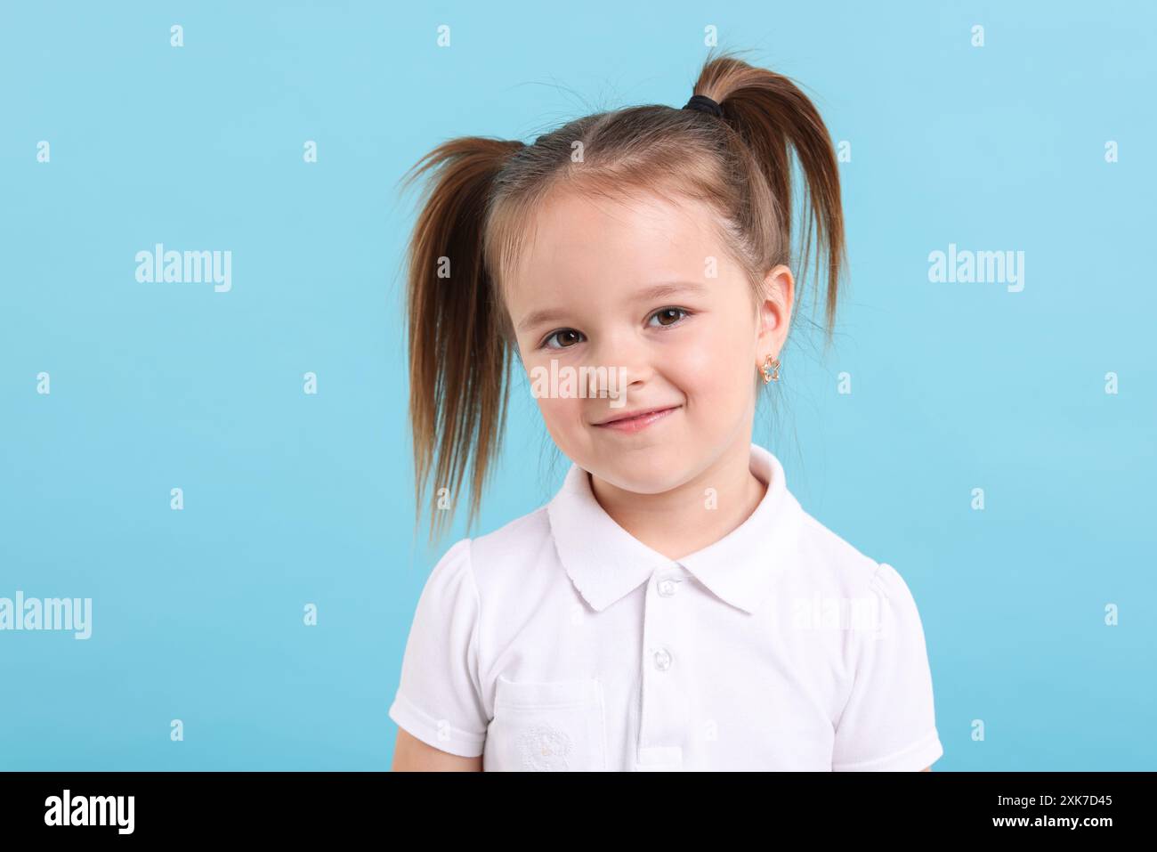 Portrait of cute little girl on light blue background Stock Photo - Alamy