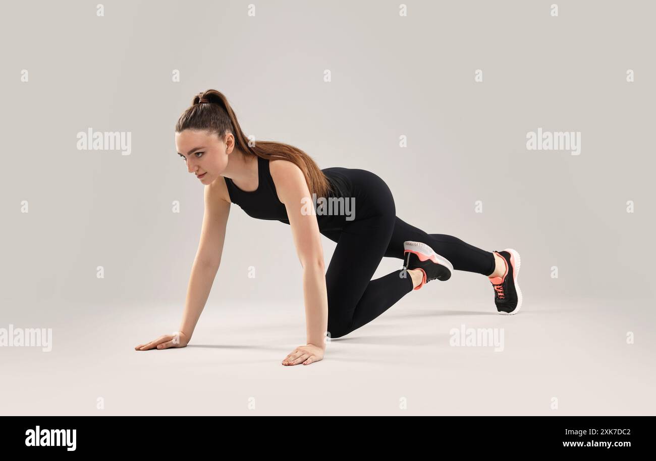 Young woman doing aerobic exercise on light background Stock Photo - Alamy