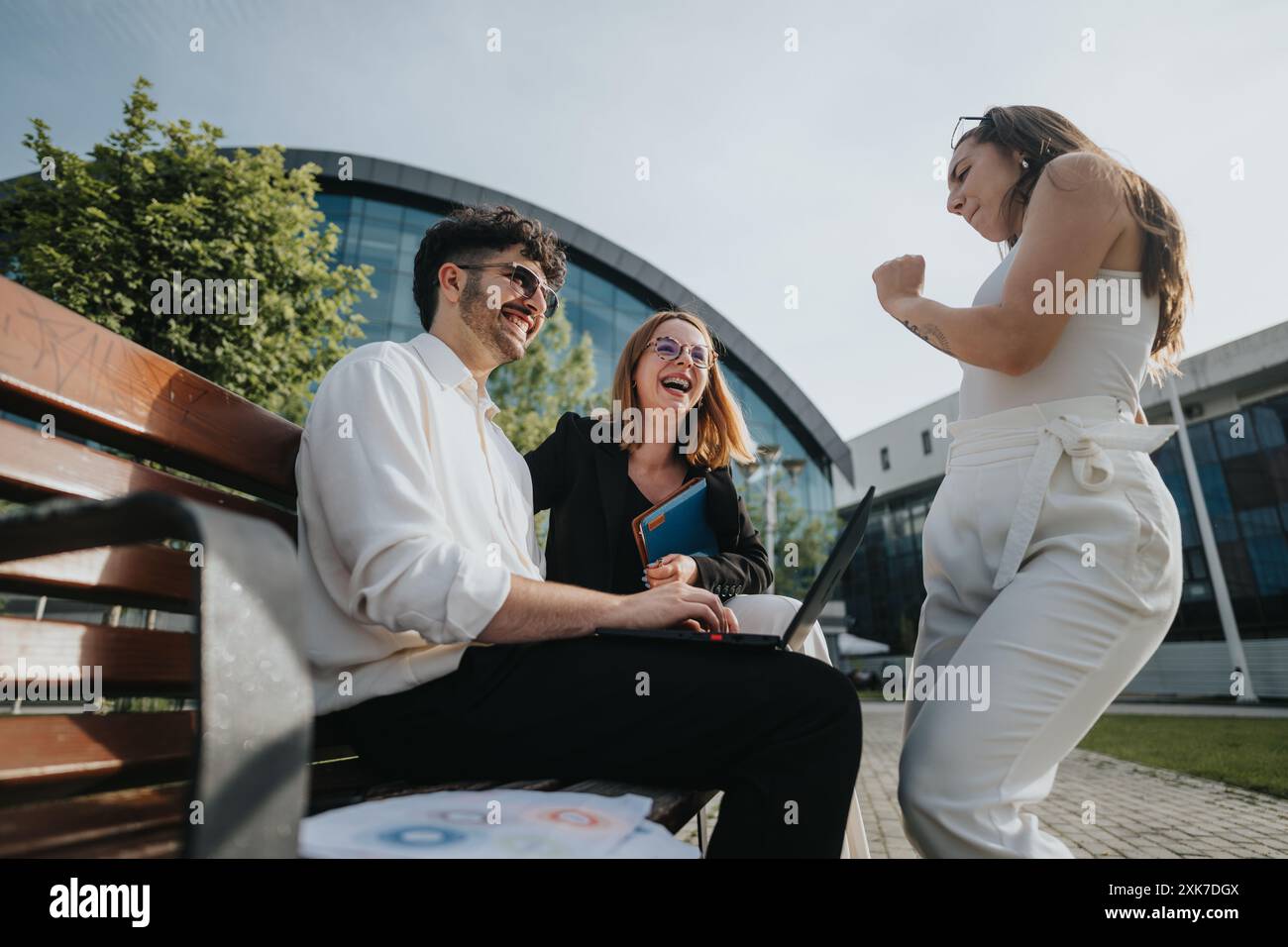 Three colleagues having a fun outdoor meeting and brainstorming session ...