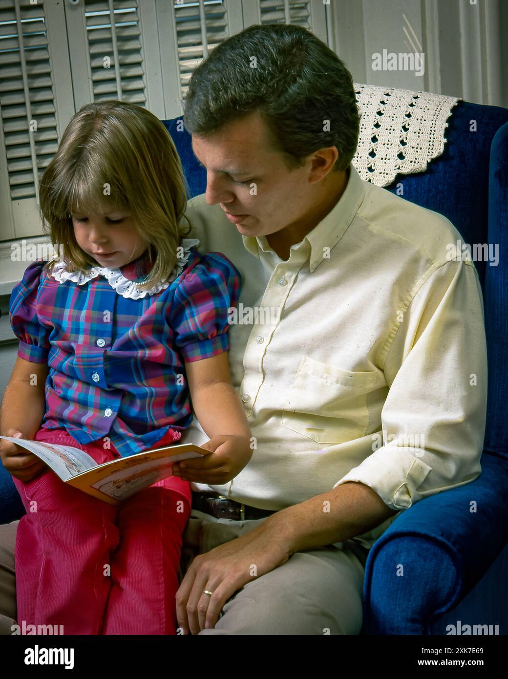 Child, parent reading book together Stock Photo - Alamy
