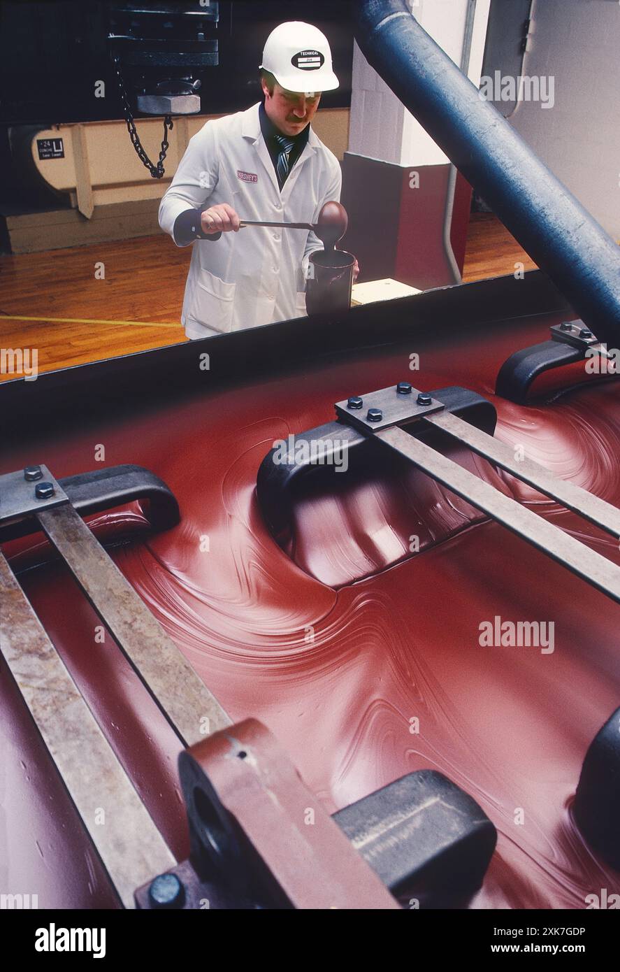 Quality control techician samples from vat of chocolate; The Hershey ...