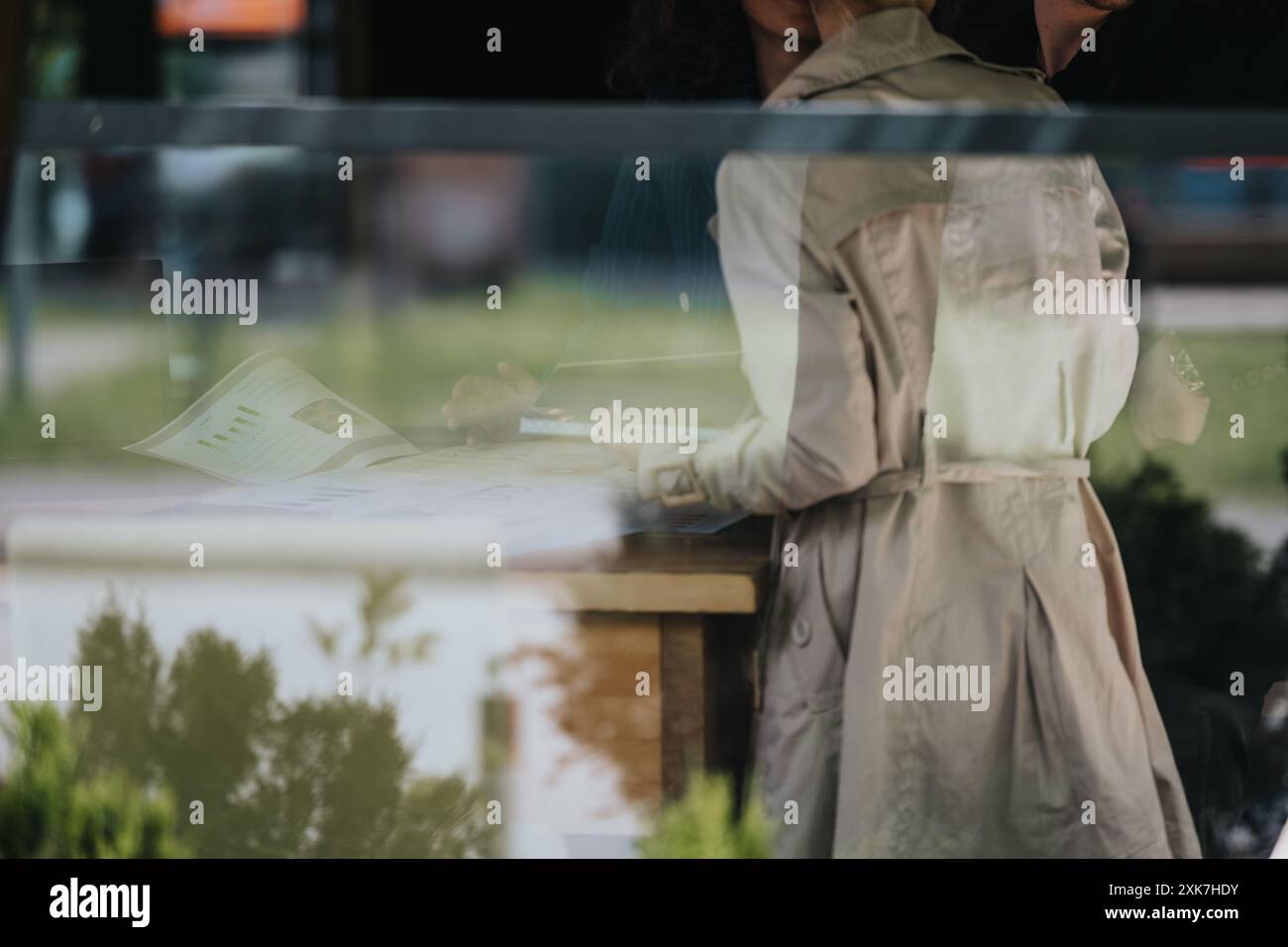 Business meeting behind glass window with documents and charts on desk ...