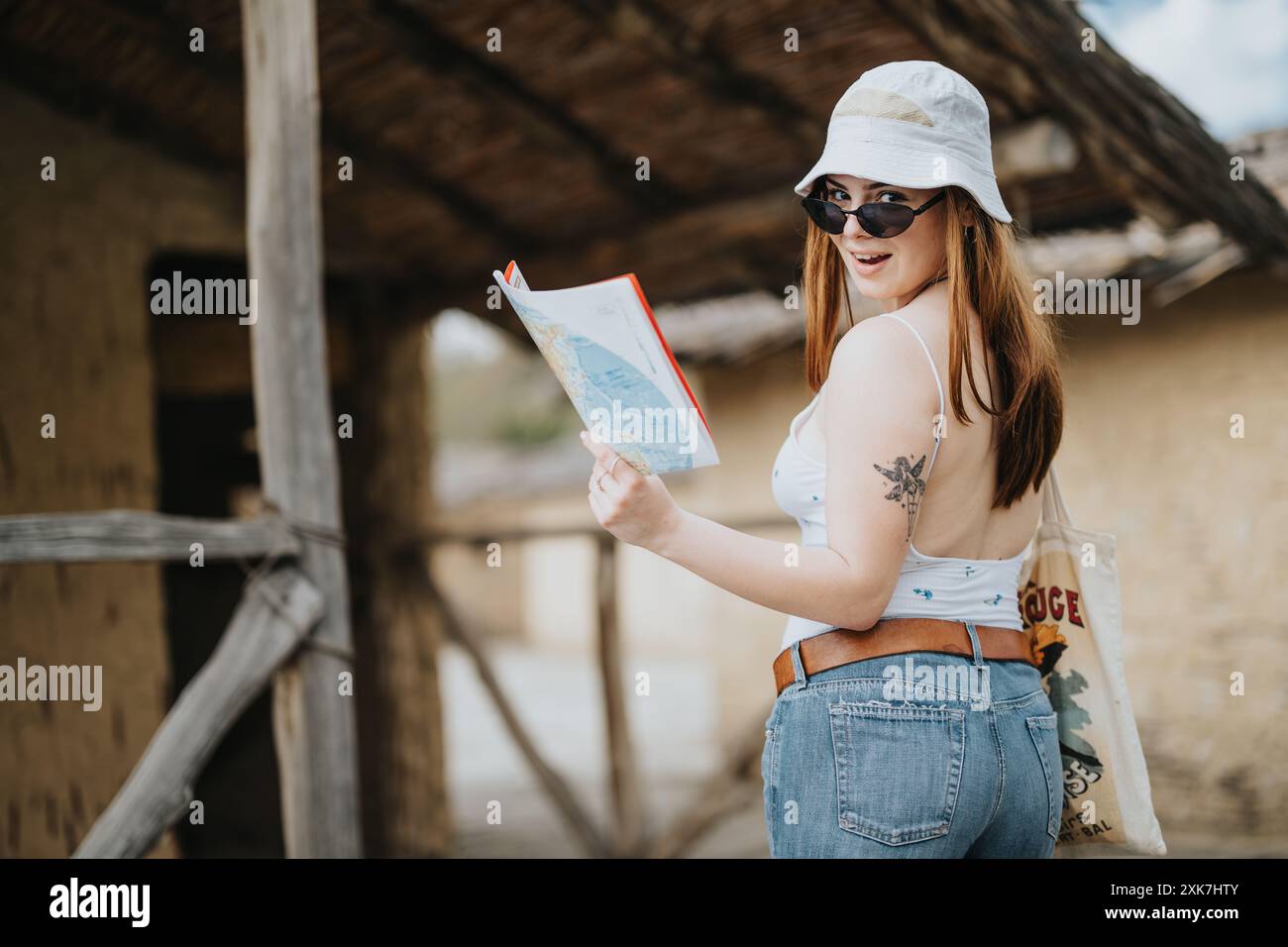 Happy tourist with a map exploring new destinations on a sunny trip ...