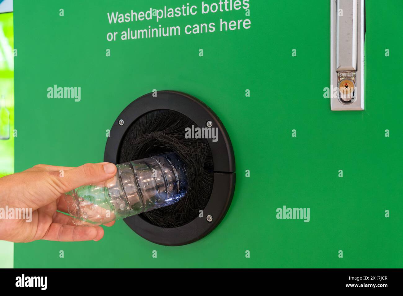 Man puts plastic bottle in a reverse vending machine. Male hand ...