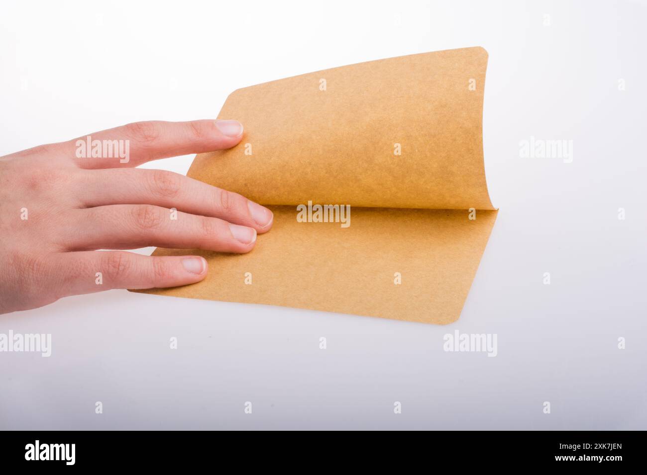 Hand holding a sheet of paper on a white background Stock Photo - Alamy