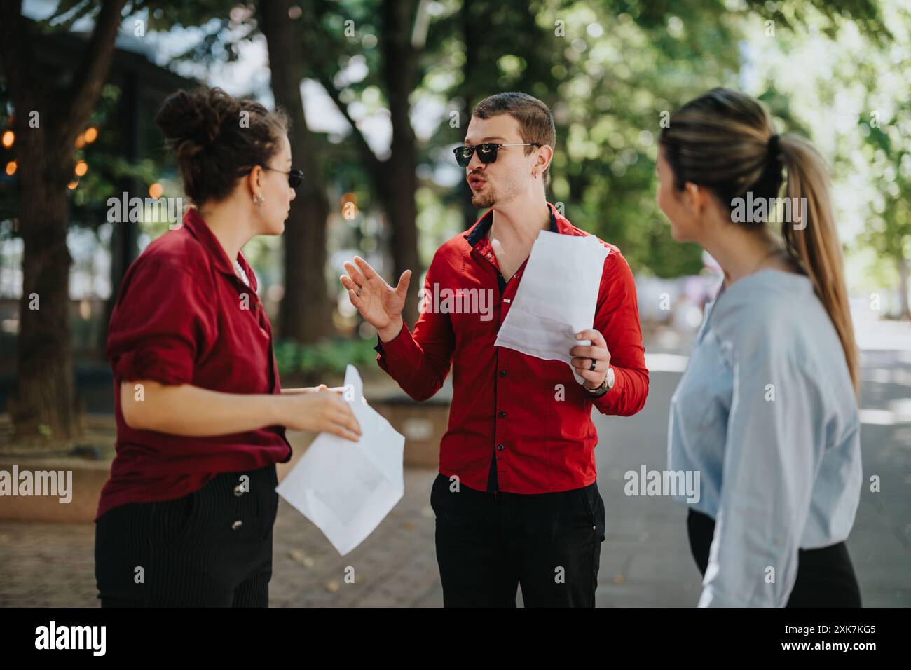 Group of business people having a discussion outdoors in a park setting ...