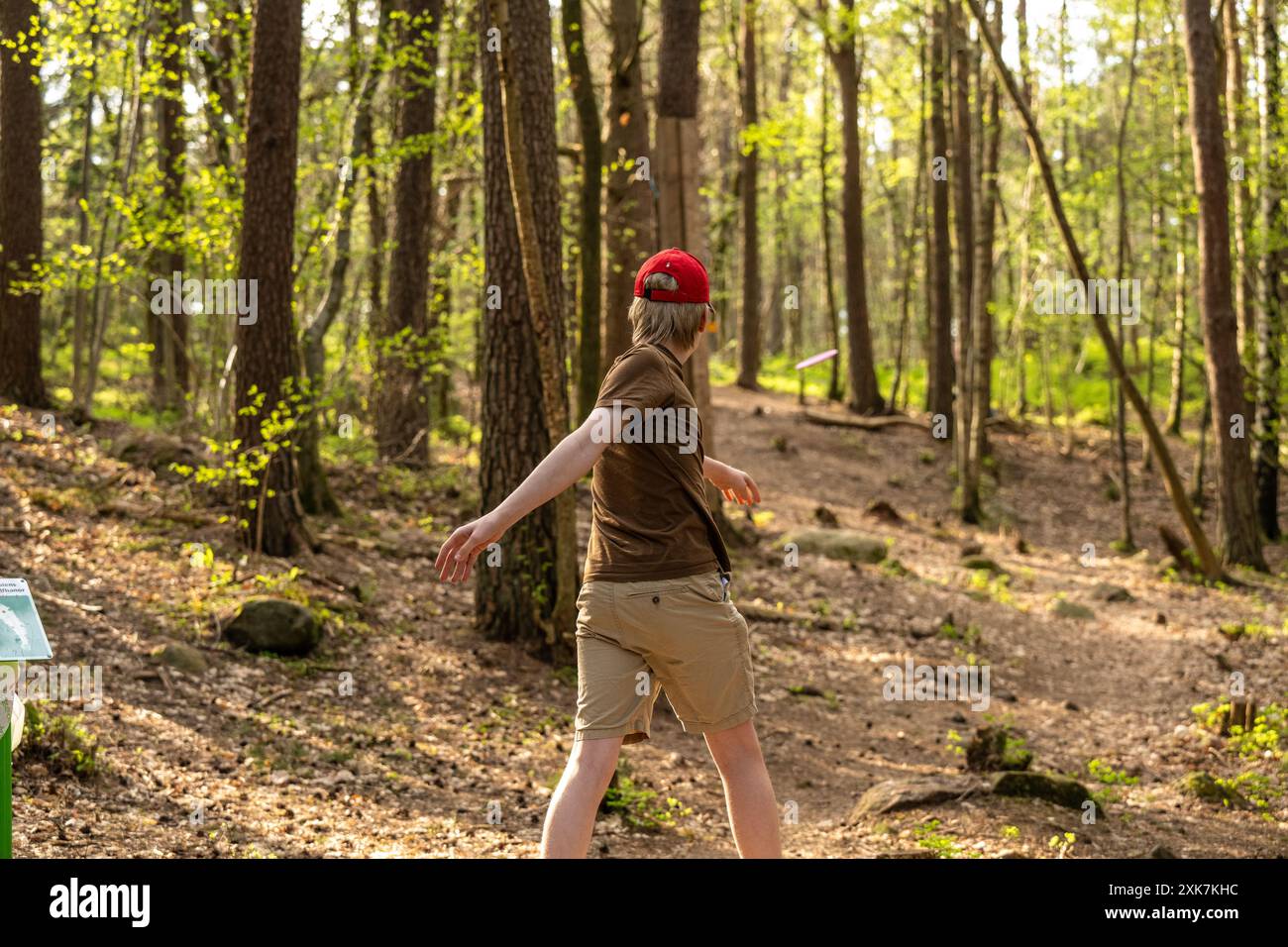 Kid throwing a disc golf frisbee Stock Photo - Alamy
