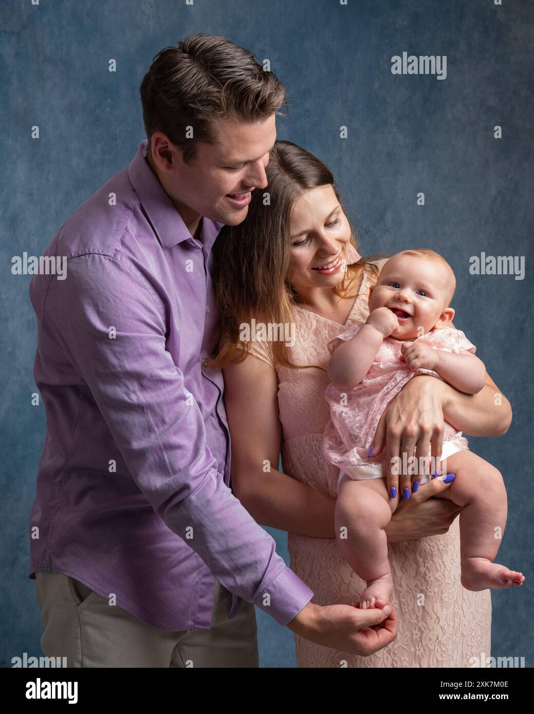 Dad, mom hold their little daughter in their arms Portrait of a young ...
