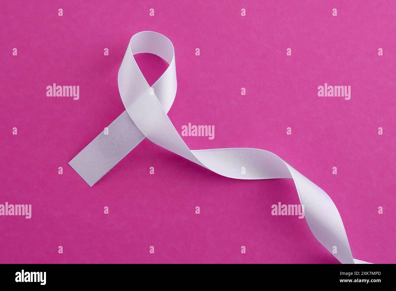 White awareness ribbon on pink background, top view Stock Photo - Alamy