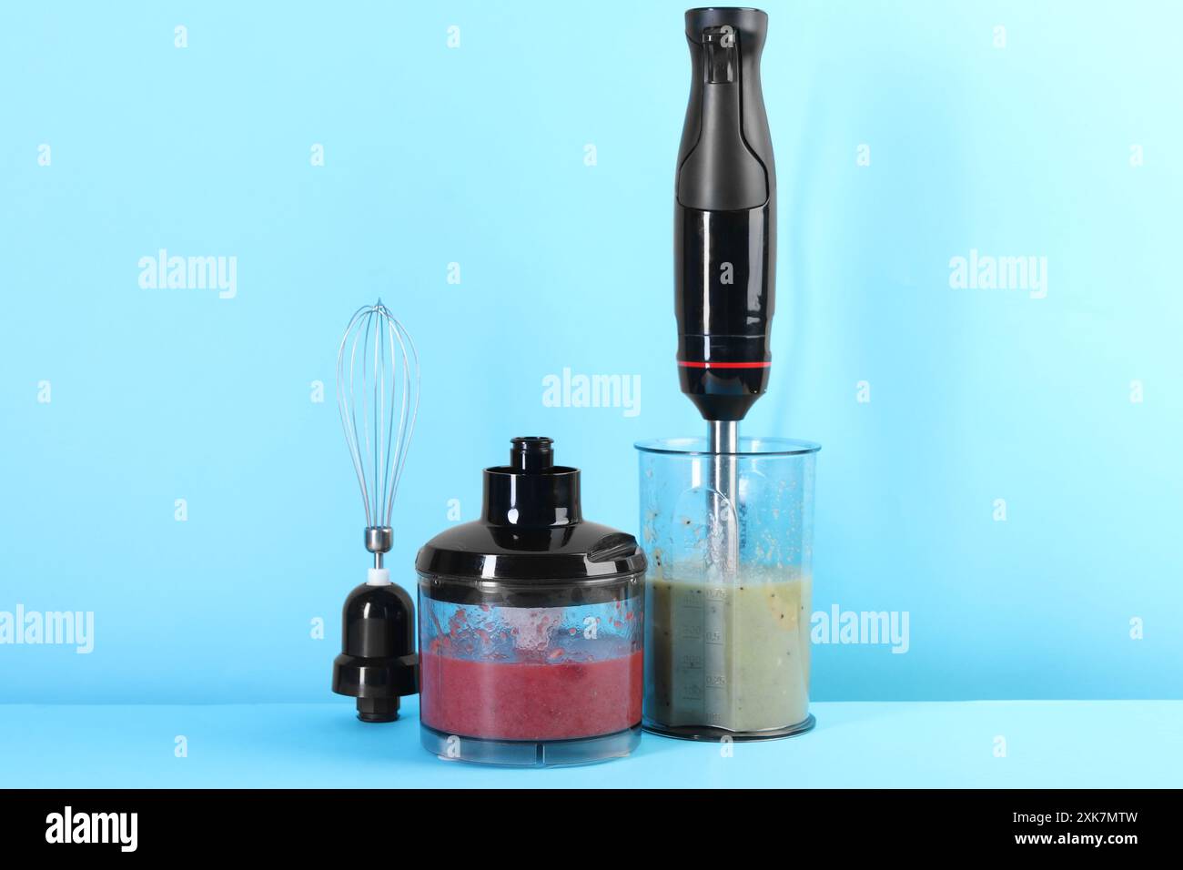 Hand blender kit and mixtures of ingredients on light blue background ...